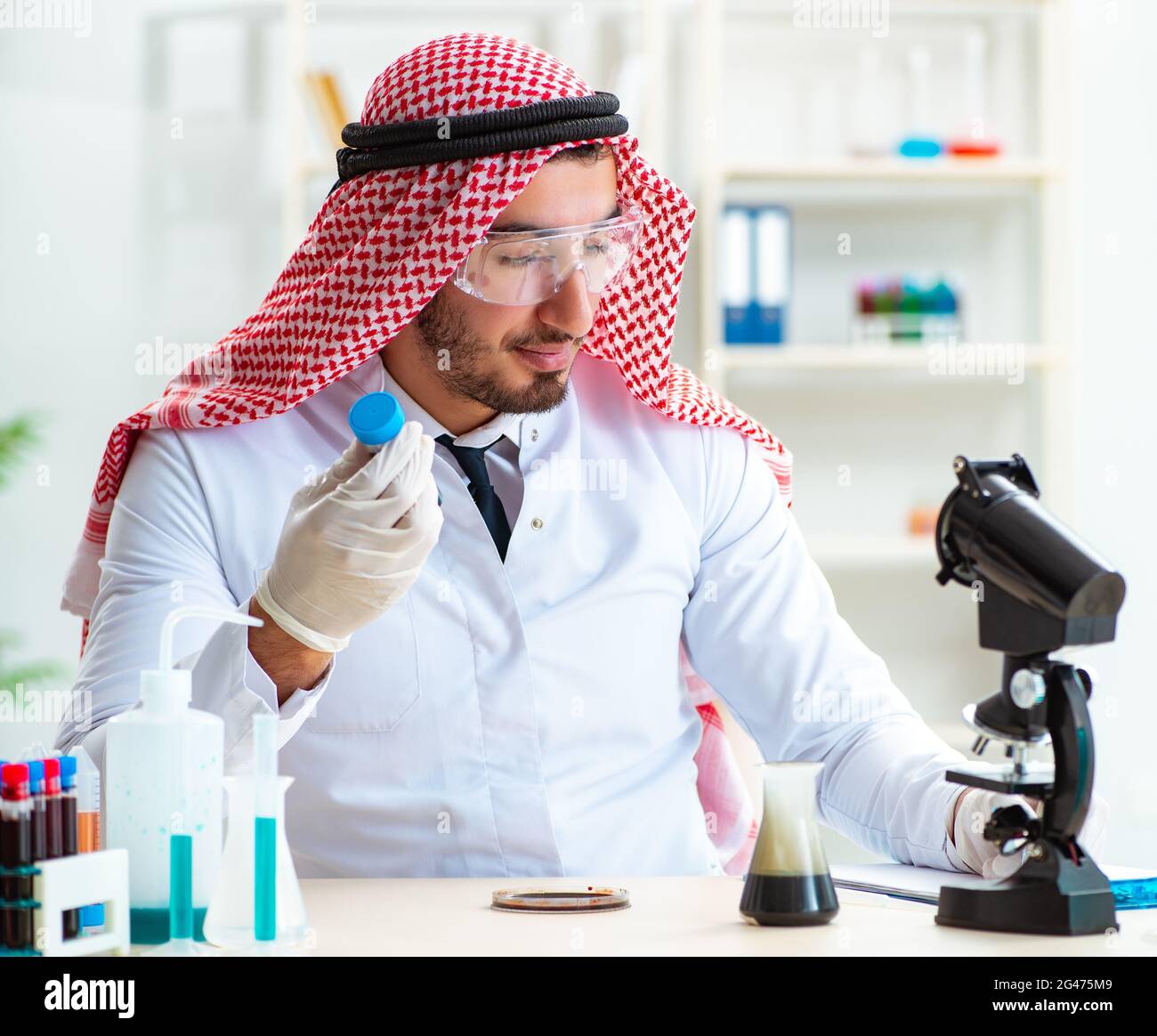 The arab chemist working in the lab office Stock Photo - Alamy