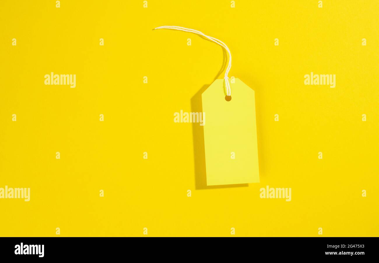 Blank rectangular paper yellow price tag with white rope on yellow ...