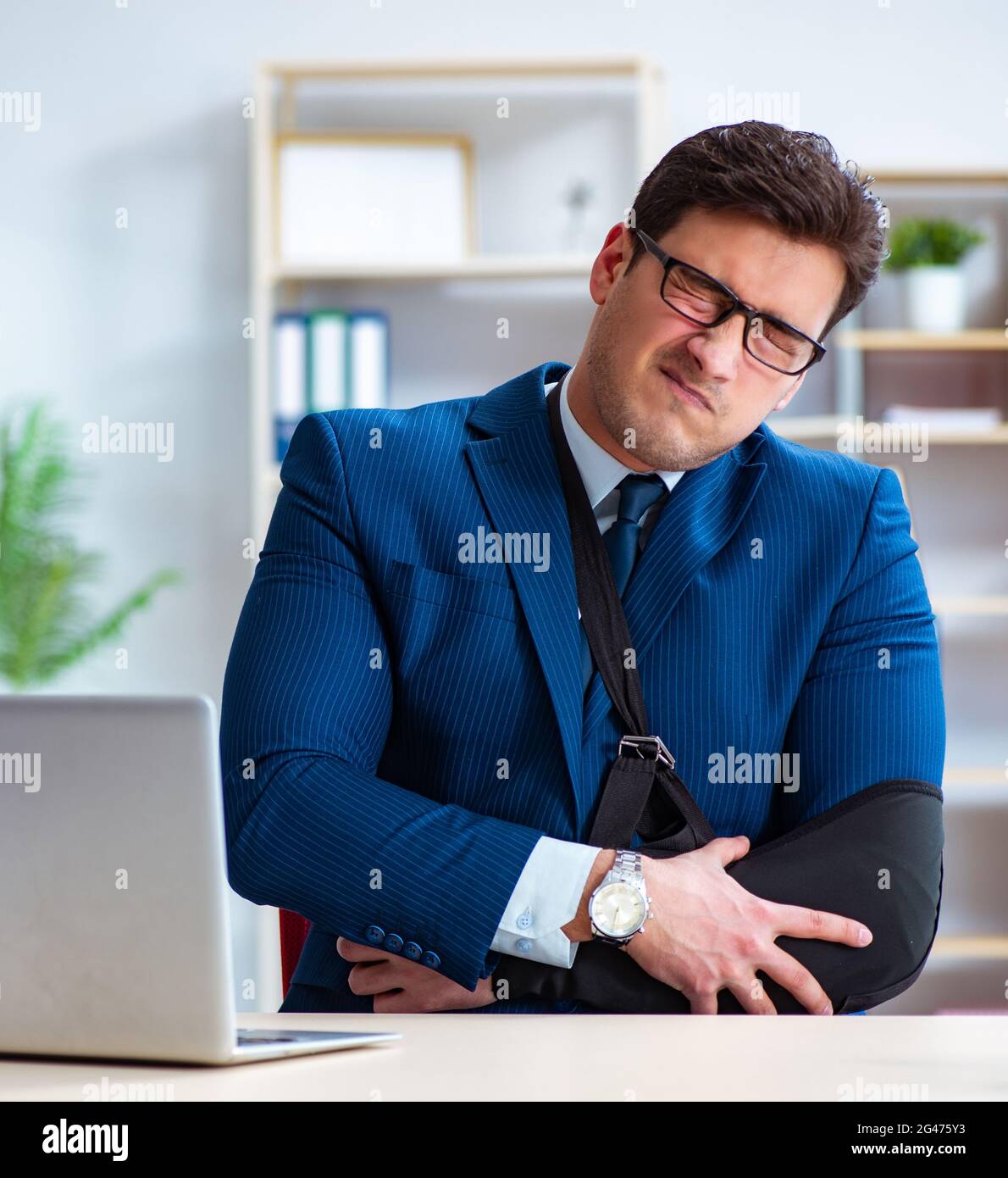 The businessman with broken arm working in office Stock Photo - Alamy