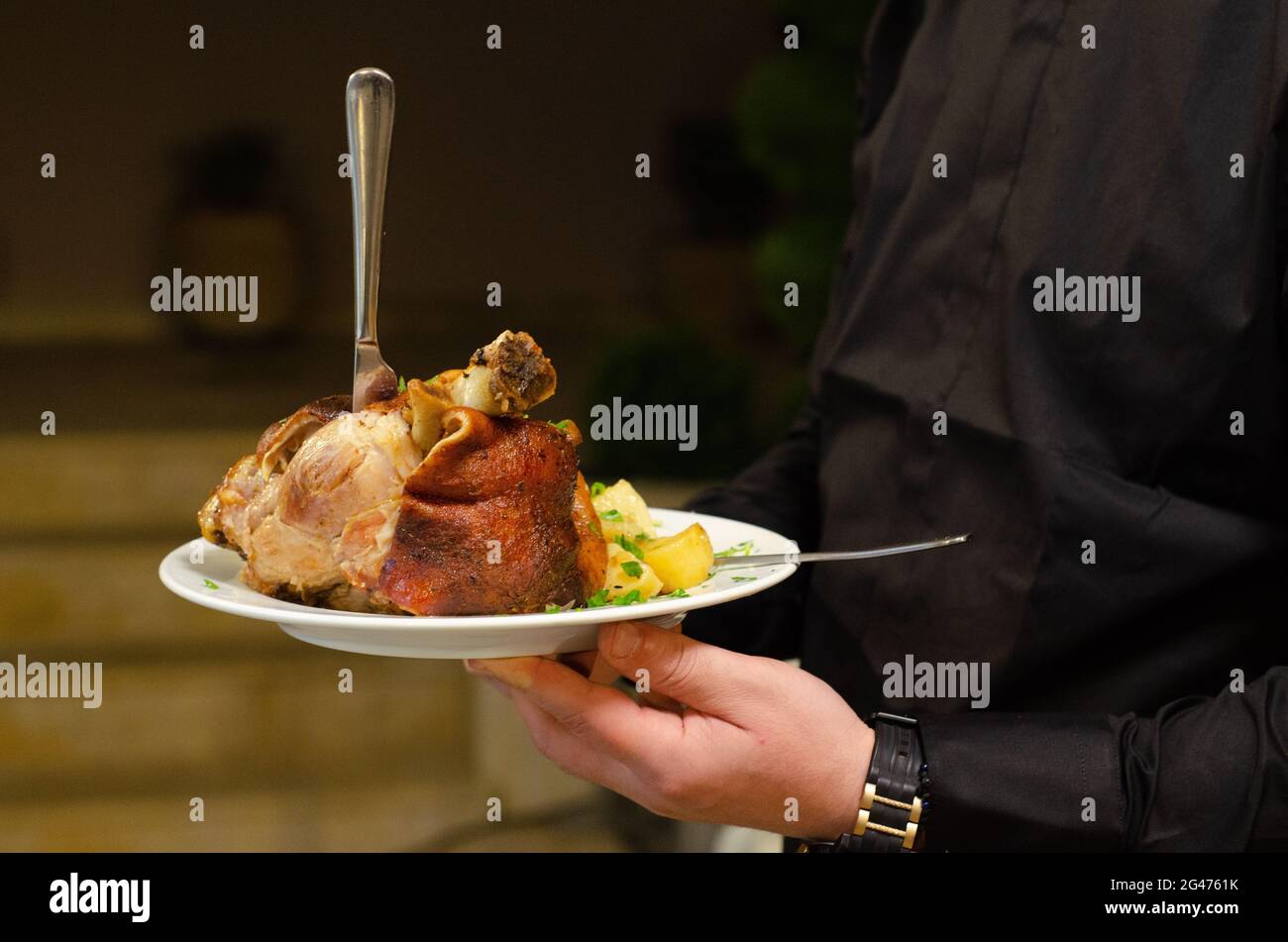 Male waiter serving baked potatoes with grilled chicken Stock Photo - Alamy