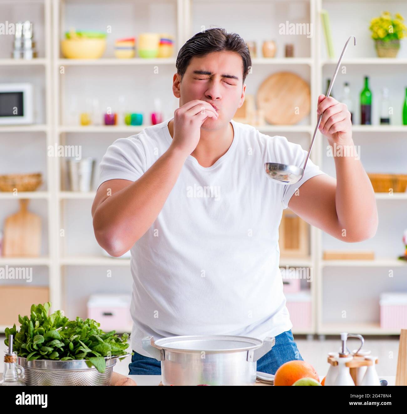 The young male cook working in the kitchen Stock Photo - Alamy