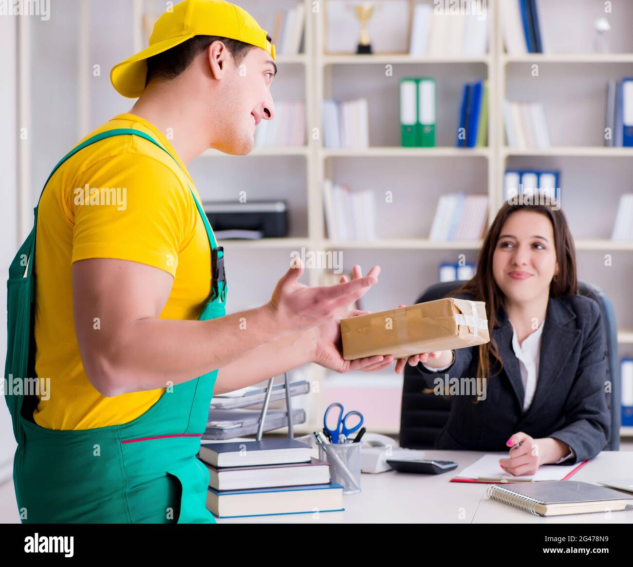 The postman delivering parcel to the office Stock Photo - Alamy