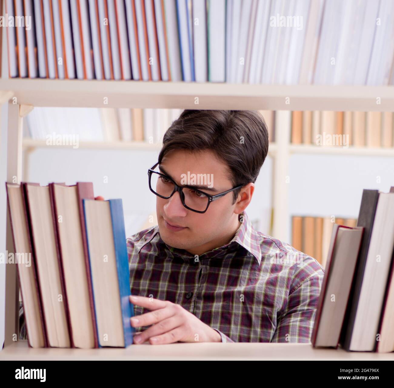 The young student looking for books in college library Stock Photo - Alamy