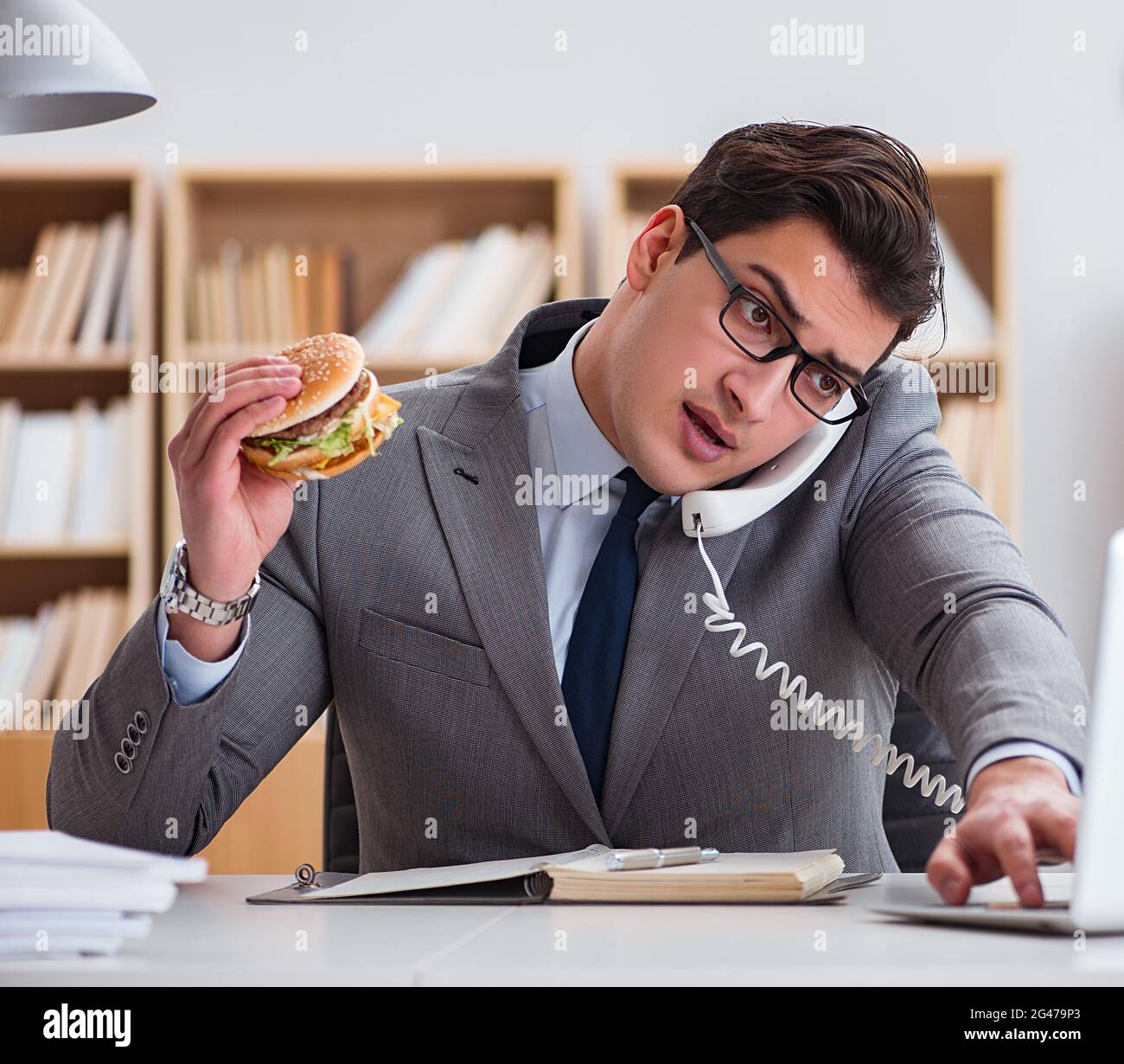 The hungry funny businessman eating junk food sandwich Stock Photo - Alamy