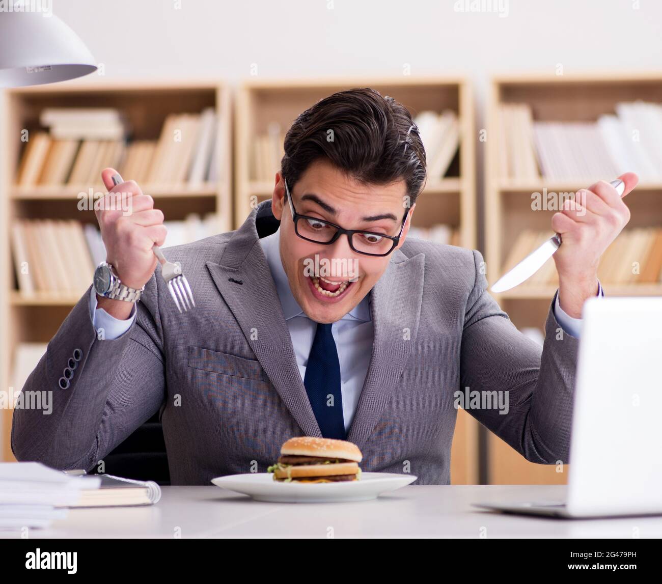 The hungry funny businessman eating junk food sandwich Stock Photo - Alamy