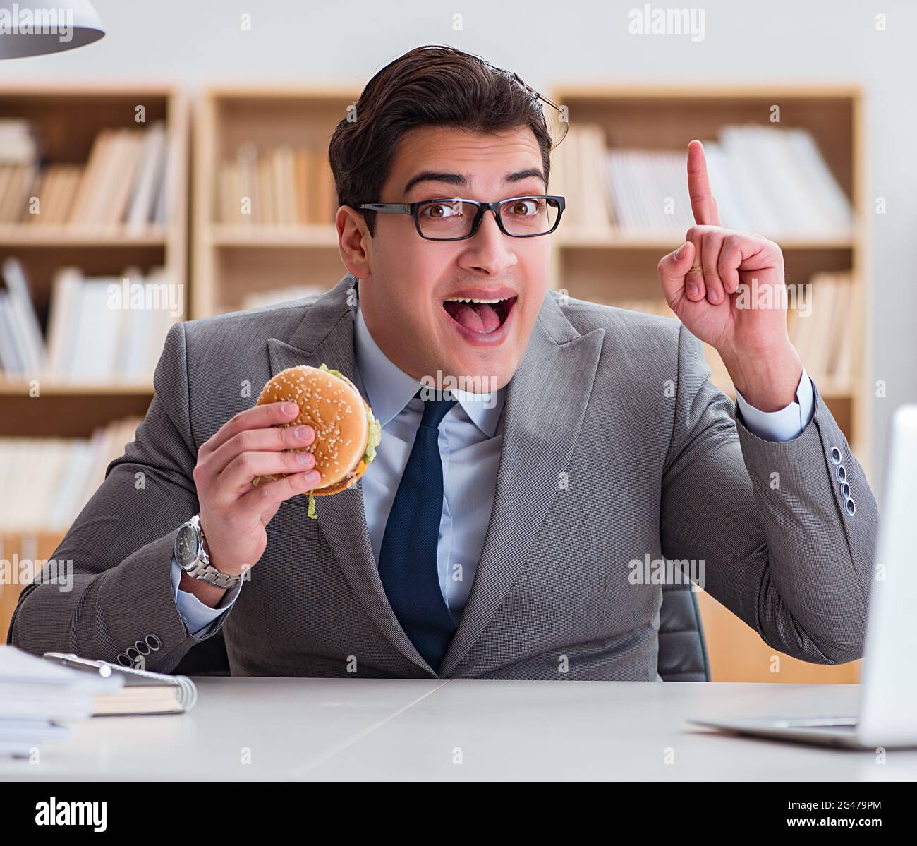 The hungry funny businessman eating junk food sandwich Stock Photo - Alamy