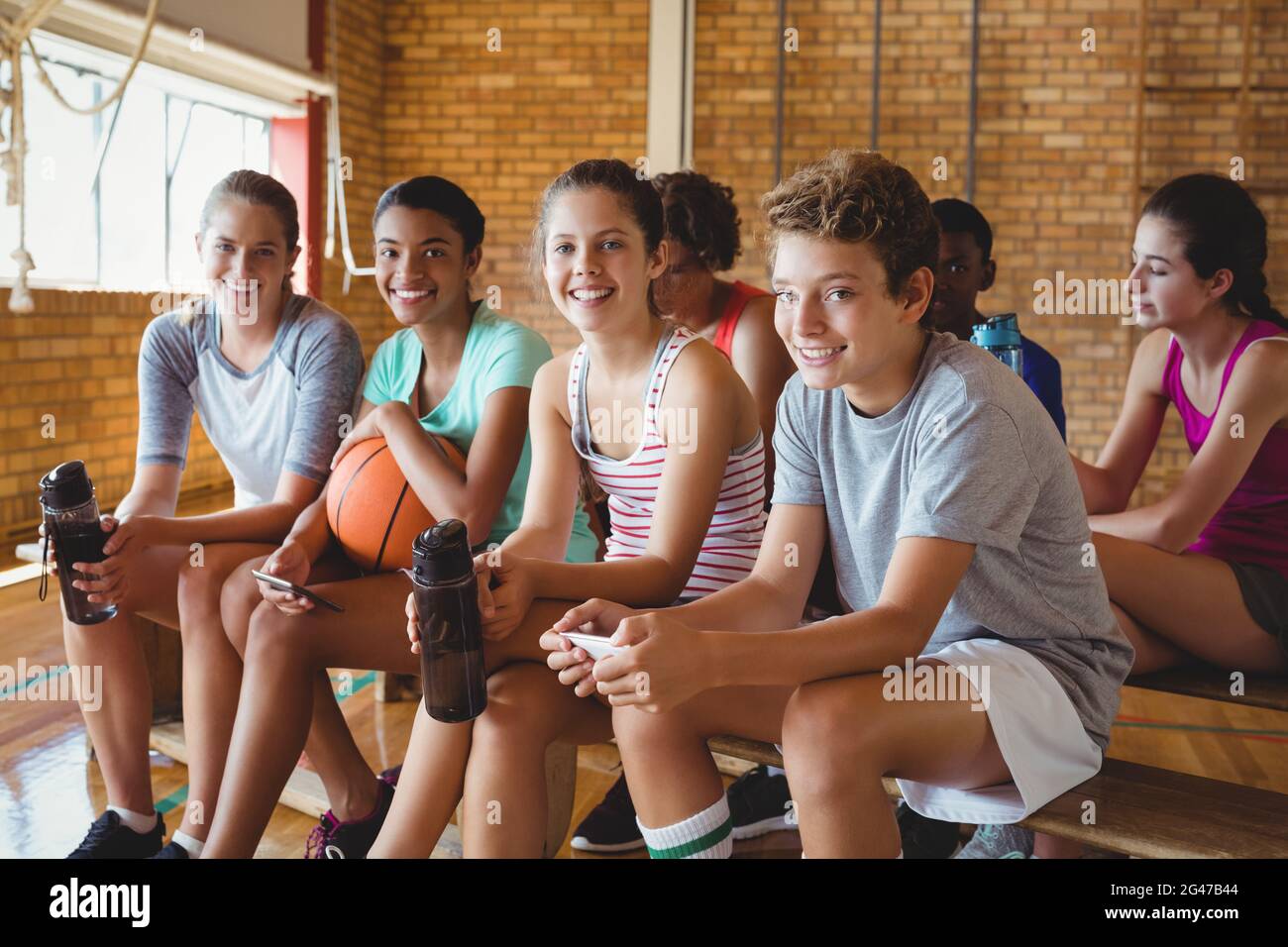 Portrait of smiling high school kids sitting on bench Stock Photo - Alamy