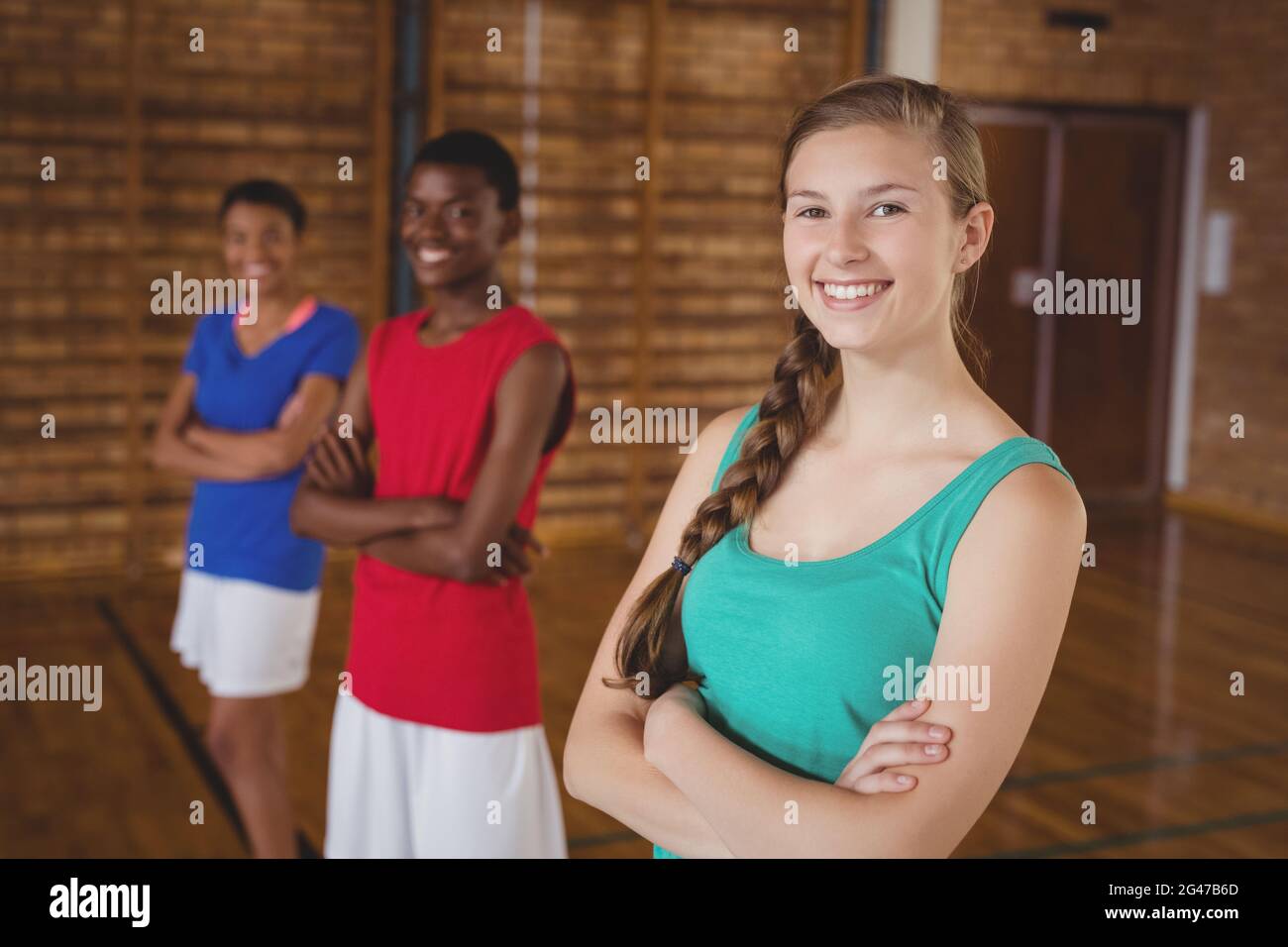High school kids standing with arms crossed in the basketball court ...