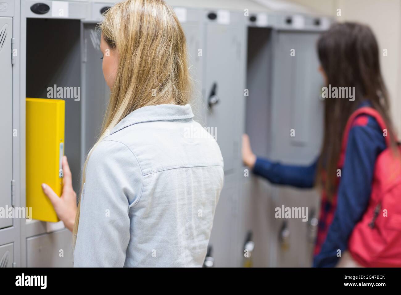 Smiling students using locker Stock Photo - Alamy