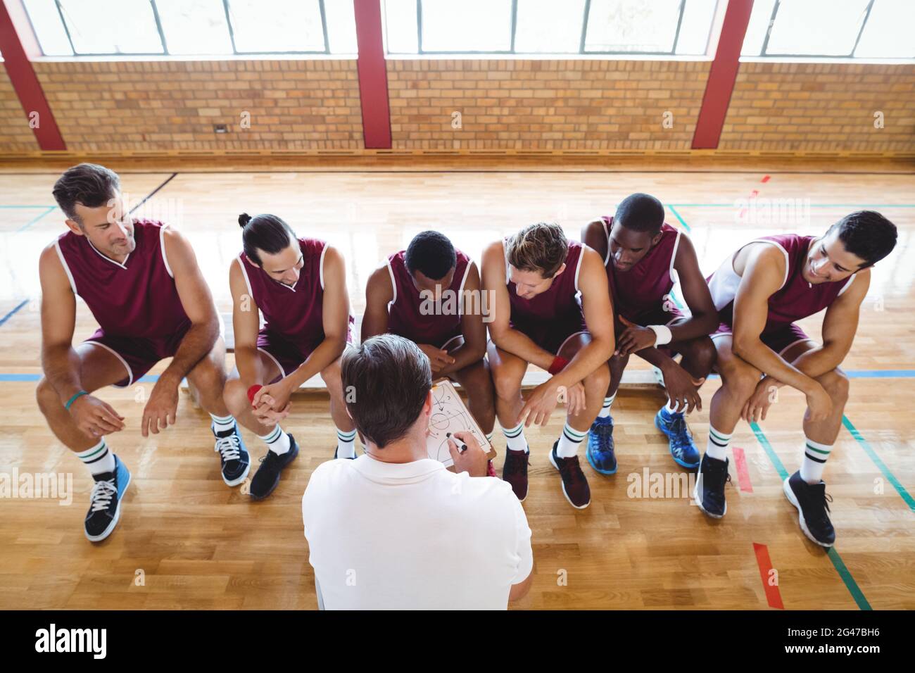 Coach explaining game plan to basketball players Stock Photo - Alamy
