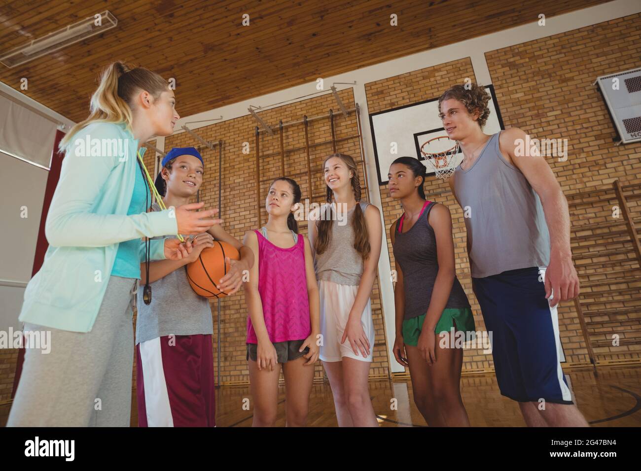 Female coach mentoring high school kids Stock Photo - Alamy