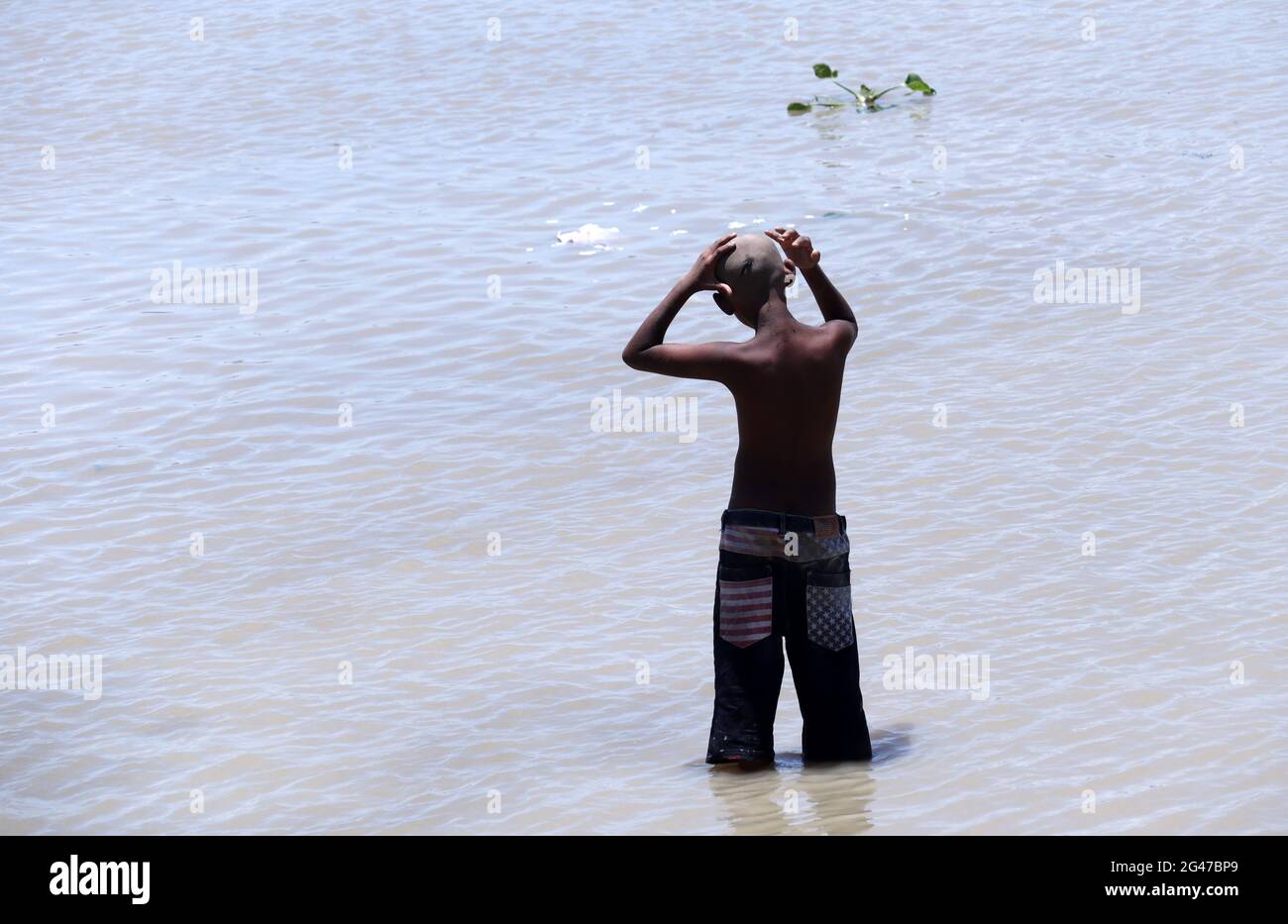 A boy takes bath in the Brahmaputra river after tonsure his hair on ...