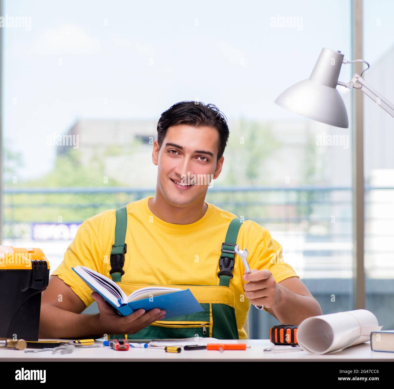 The construction worker sitting at the desk Stock Photo - Alamy