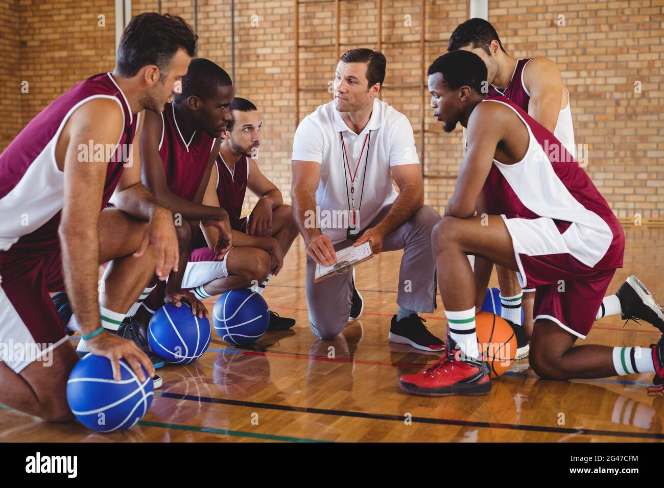 Coach explaining game plan to basketball players Stock Photo - Alamy