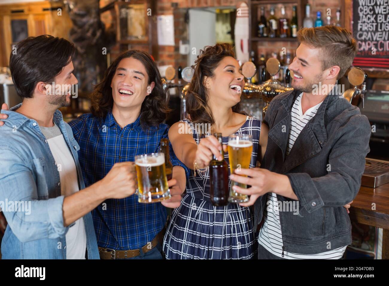 Cheerful friends enjoying in pub Stock Photo - Alamy