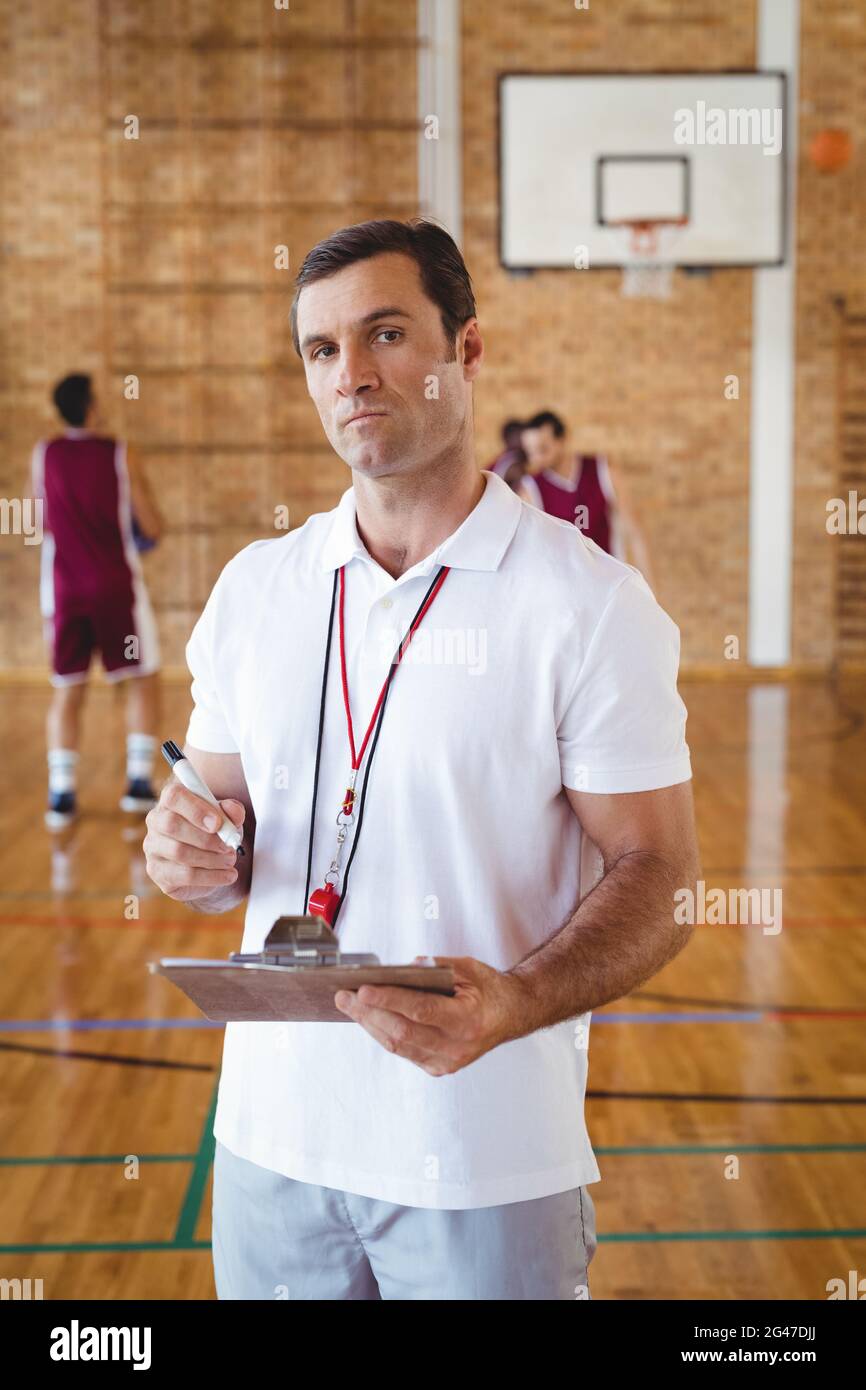 Basketball coach holding clipboard in the court Stock Photo - Alamy