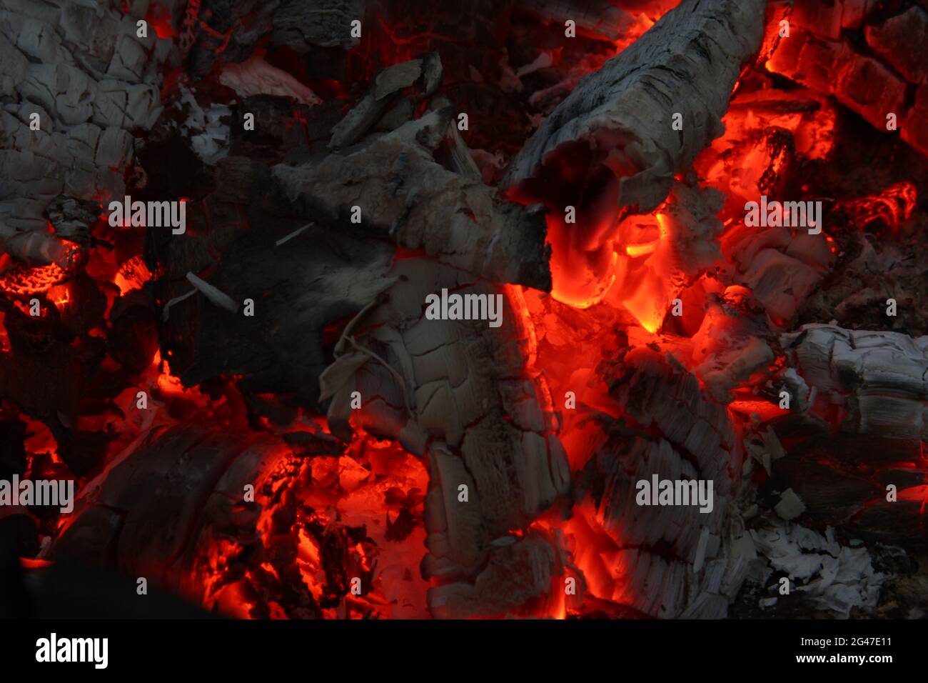Smoldered logs burned in vivid fire close up. Atmospheric background ...