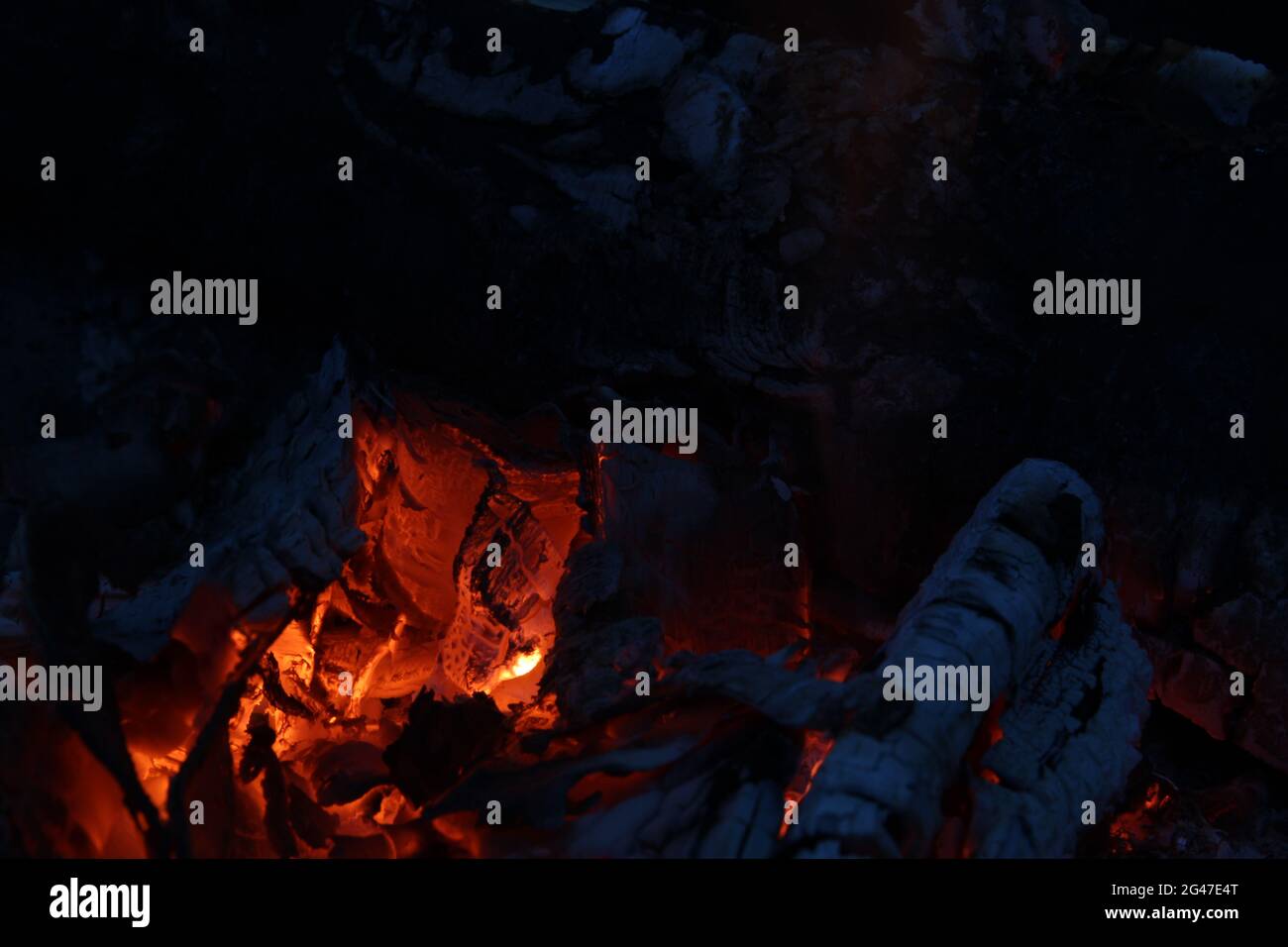 Smoldered logs burned in vivid fire close up. Atmospheric background ...