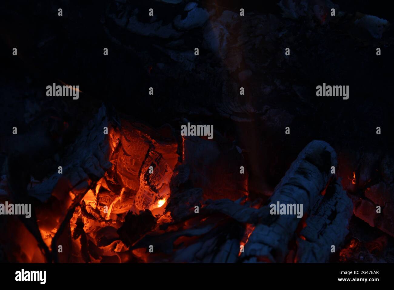 Smoldered logs burned in vivid fire close up. Atmospheric background ...