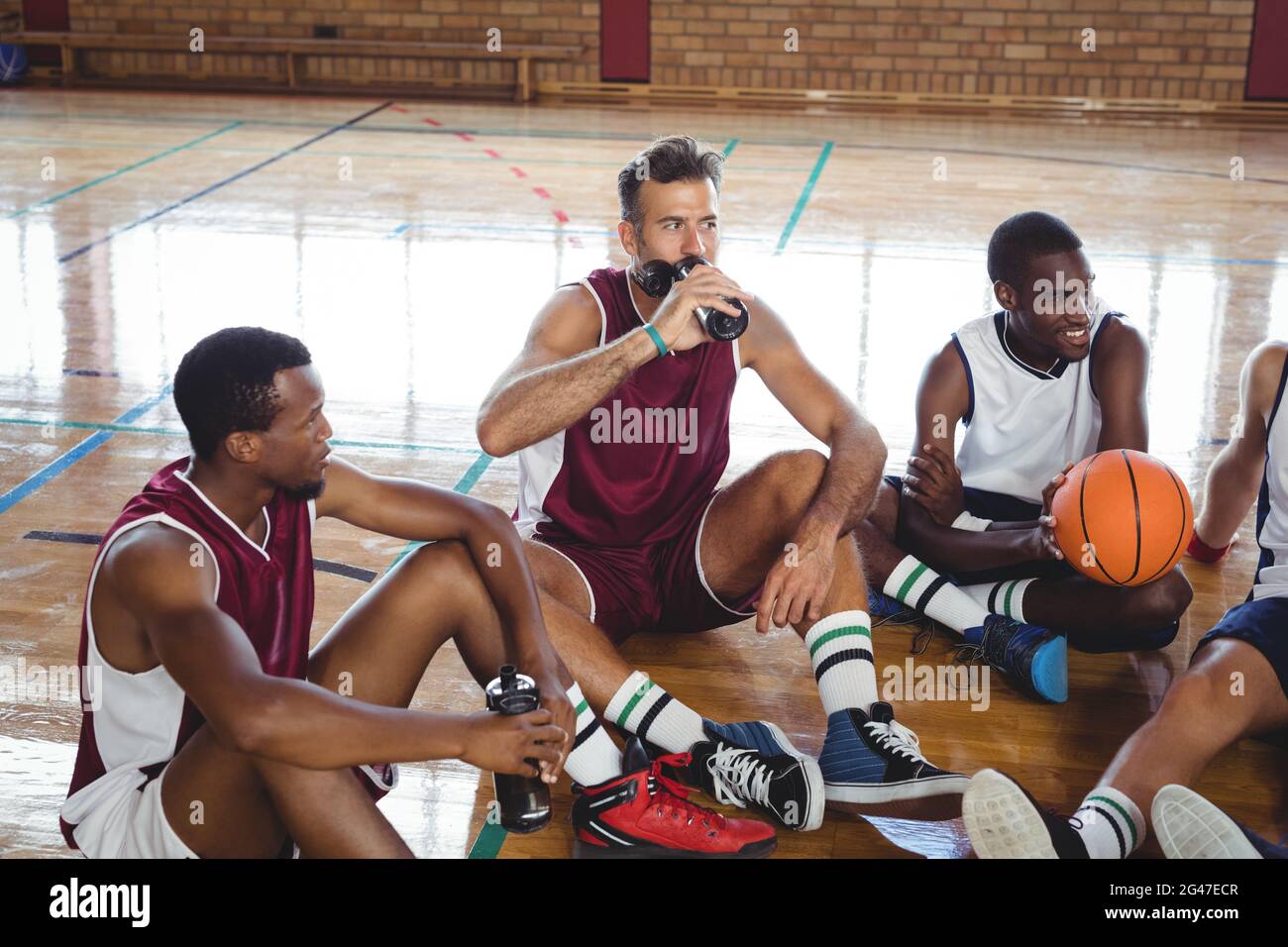 Basketball players interacting while relaxing Stock Photo - Alamy