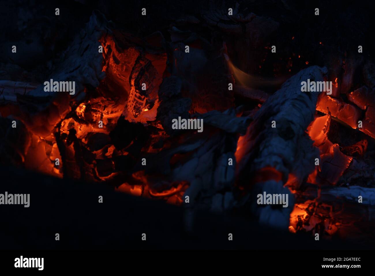 Smoldered logs burned in vivid fire close up. Atmospheric background ...