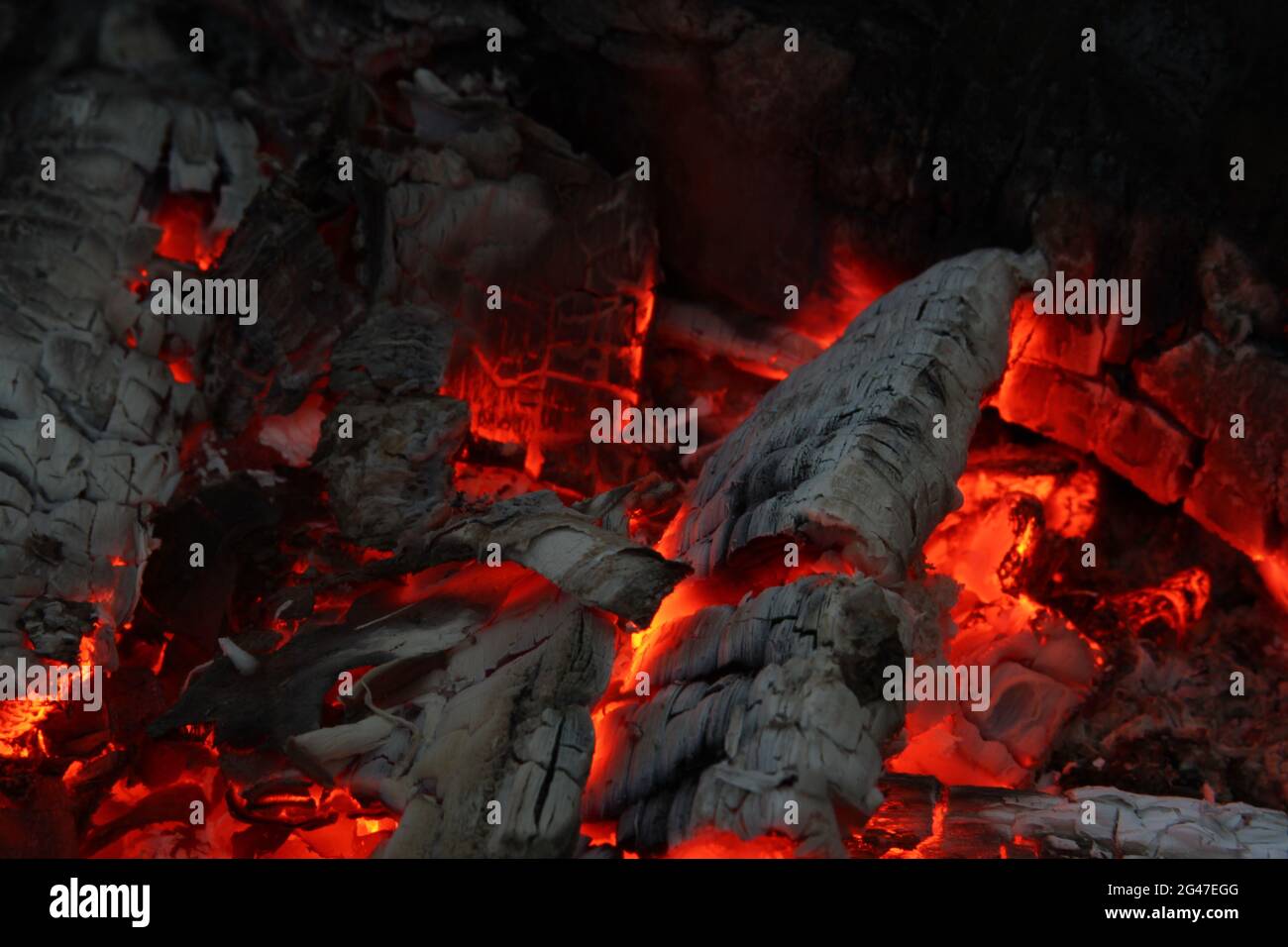 Smoldered logs burned in vivid fire close up. Atmospheric background ...