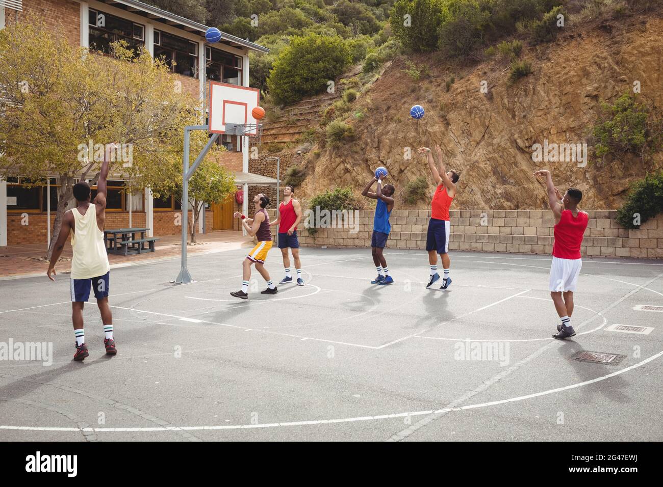 Basketball players practicing in basketball court Stock Photo - Alamy