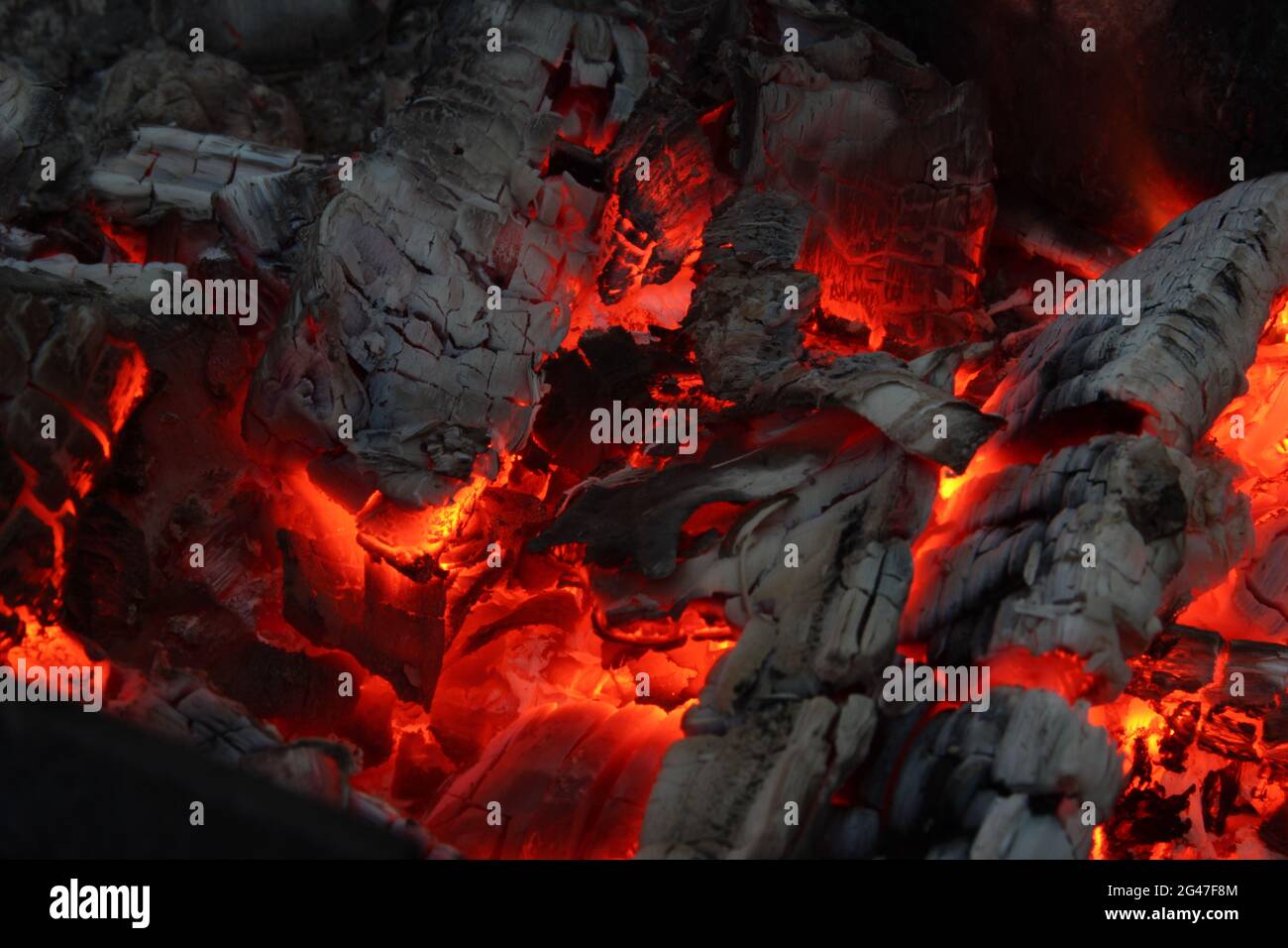 Smoldered logs burned in vivid fire close up. Atmospheric background ...