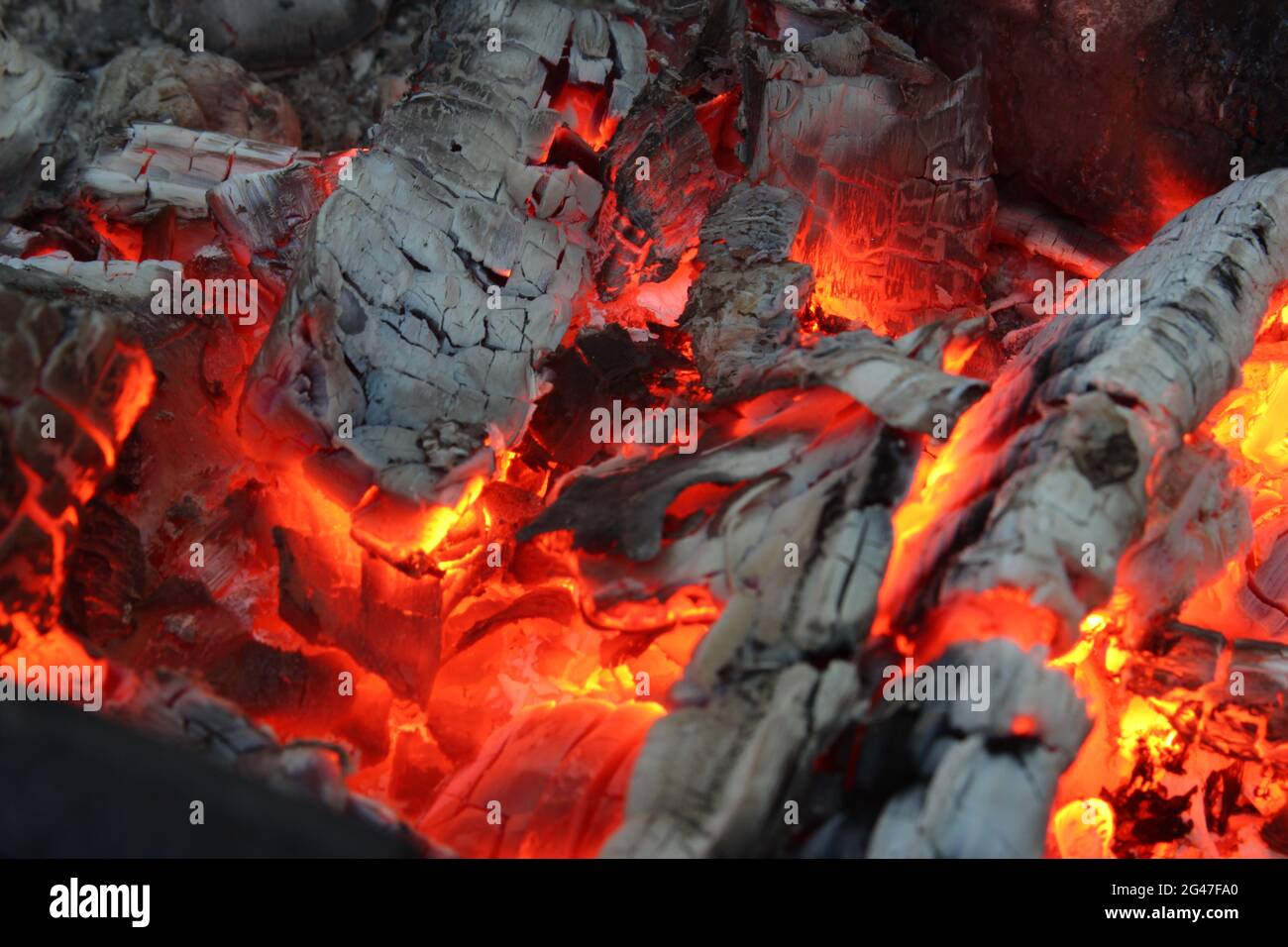 Smoldered logs burned in vivid fire close up. Atmospheric background ...