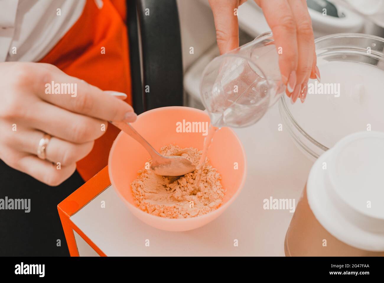 The beautician mixes the golden mask before applying on the face ...