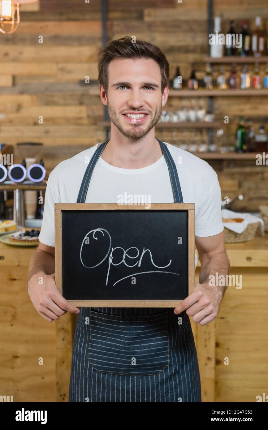 Male waiter standing open sign hi-res stock photography and images - Alamy