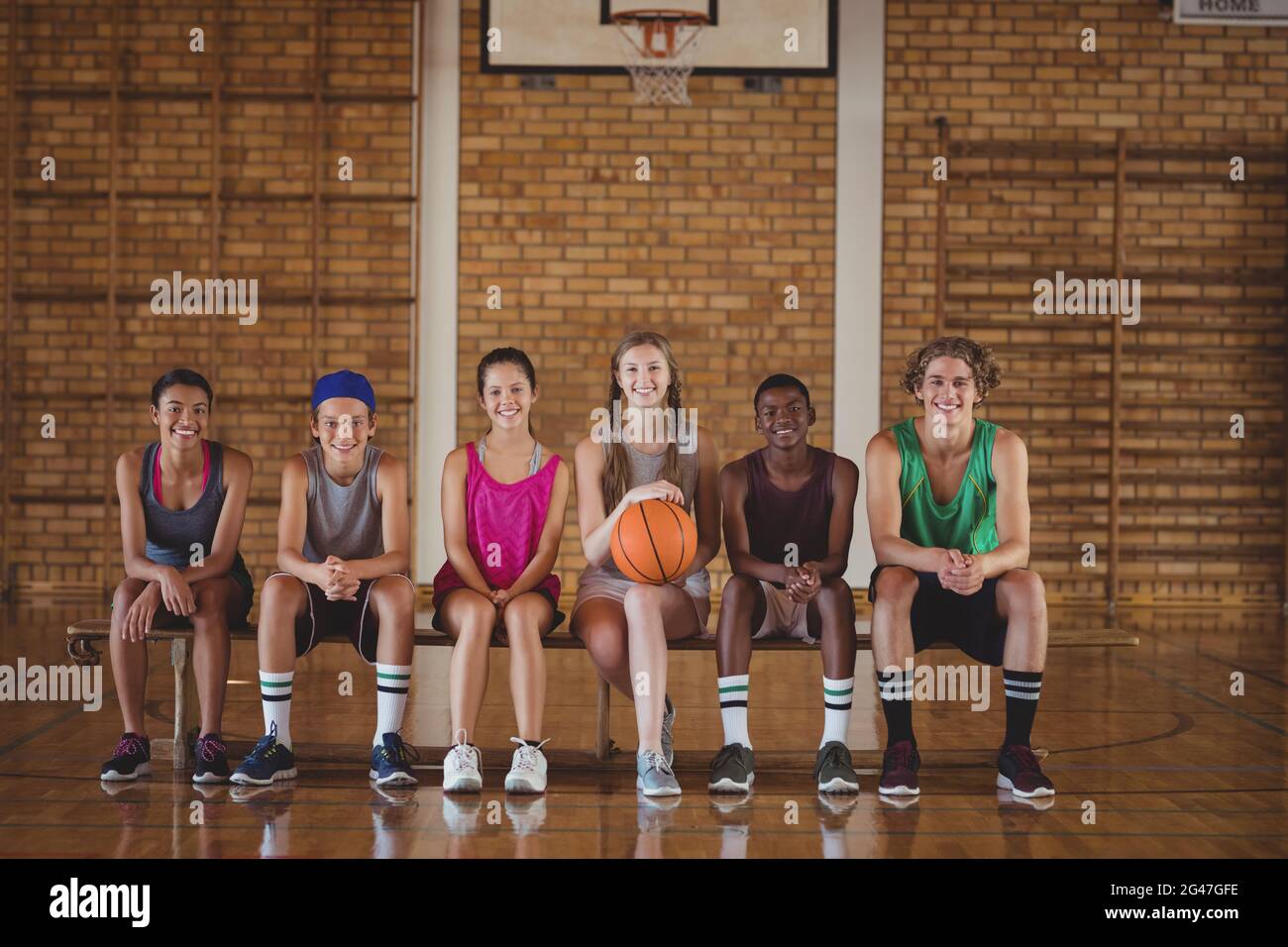 High school kids sitting on a bench in basketball court Stock Photo - Alamy