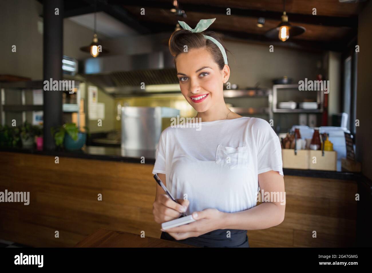 Portrait of smiling waitress in restaurant Stock Photo - Alamy