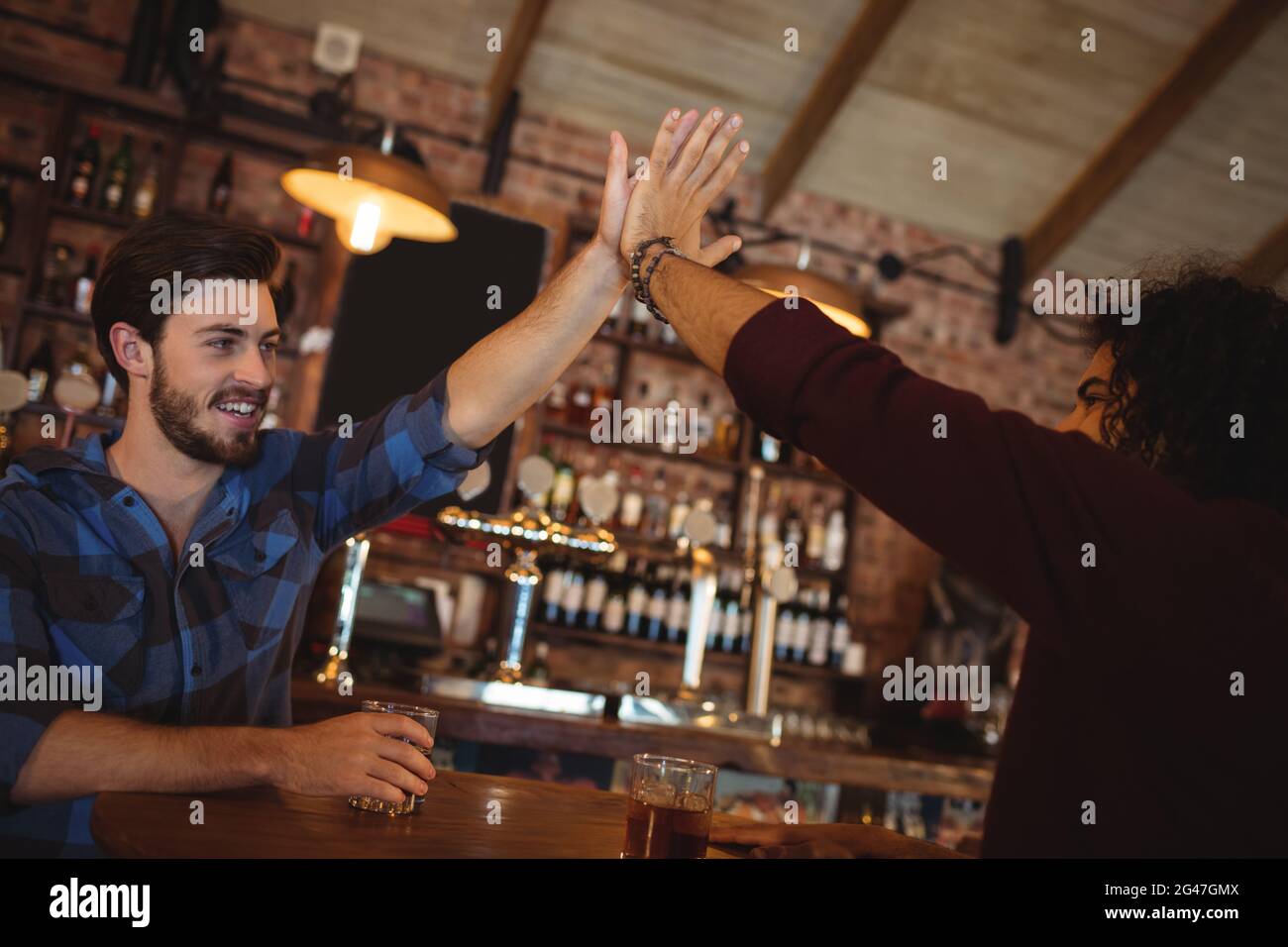 Two young men giving high five to each other Stock Photo - Alamy