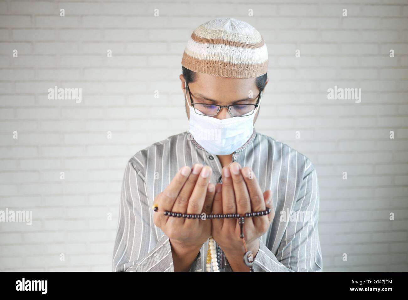 muslim man with face mask keep hand in praying gestures during ramadan ...