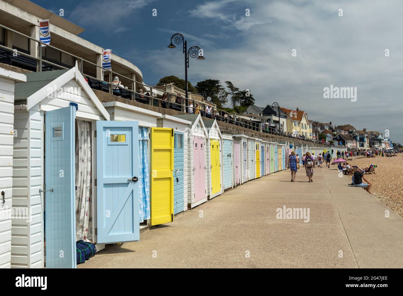 Row of pastel coloured beach huts besides the beach at Lyme Regis ...