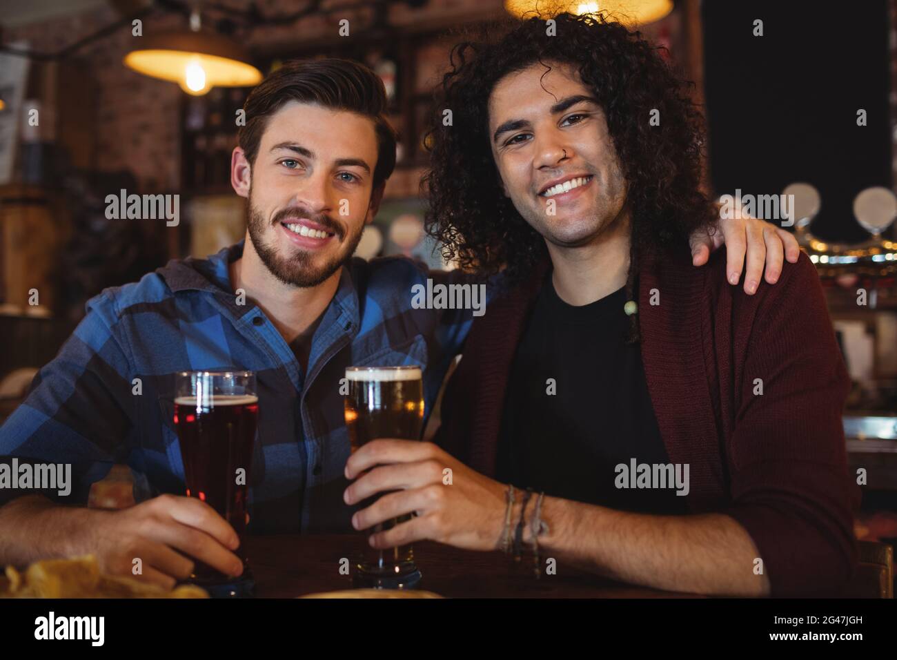 Friends having beer at bar counter Stock Photo - Alamy