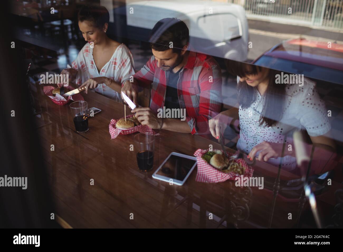 Friends having burger together Stock Photo - Alamy