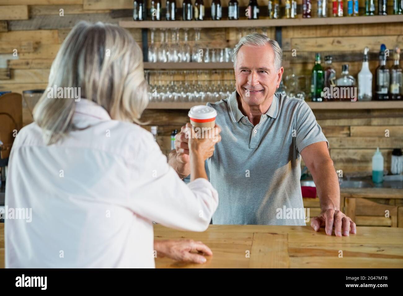 Senior man serving coffee to woman Stock Photo - Alamy