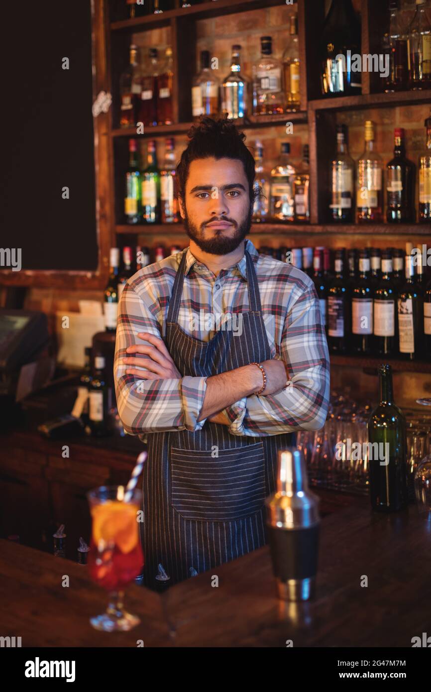 Portrait of waiter standing with arms crossed at counter Stock Photo ...