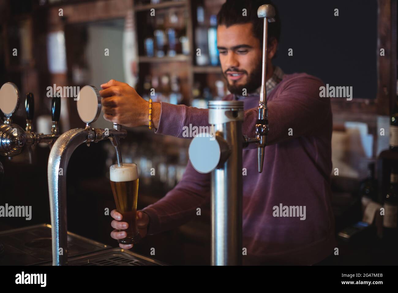 Bar tender filling beer from bar pump Stock Photo - Alamy