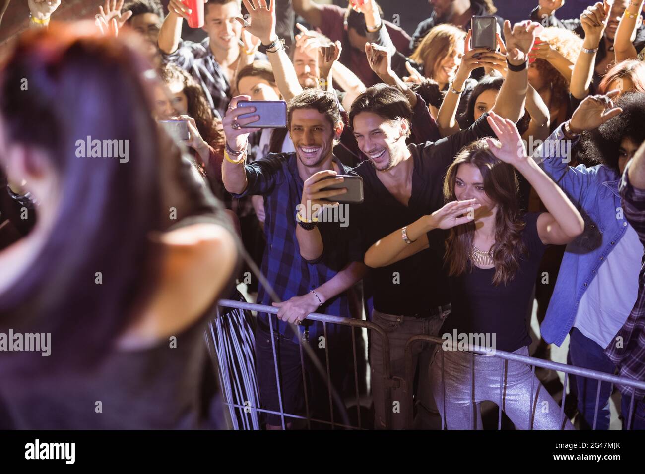 Cheerful young crowd photographing performer at nightclub Stock Photo ...
