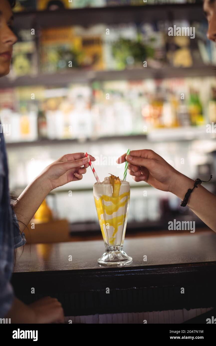 Couple having milkshake at counter Stock Photo - Alamy