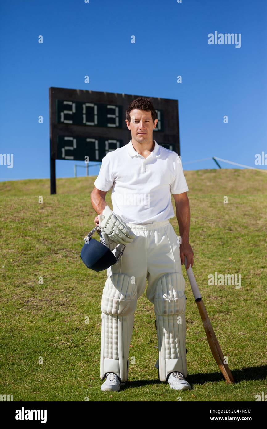 Portrait of cricket player standing against scoreboard Stock Photo - Alamy