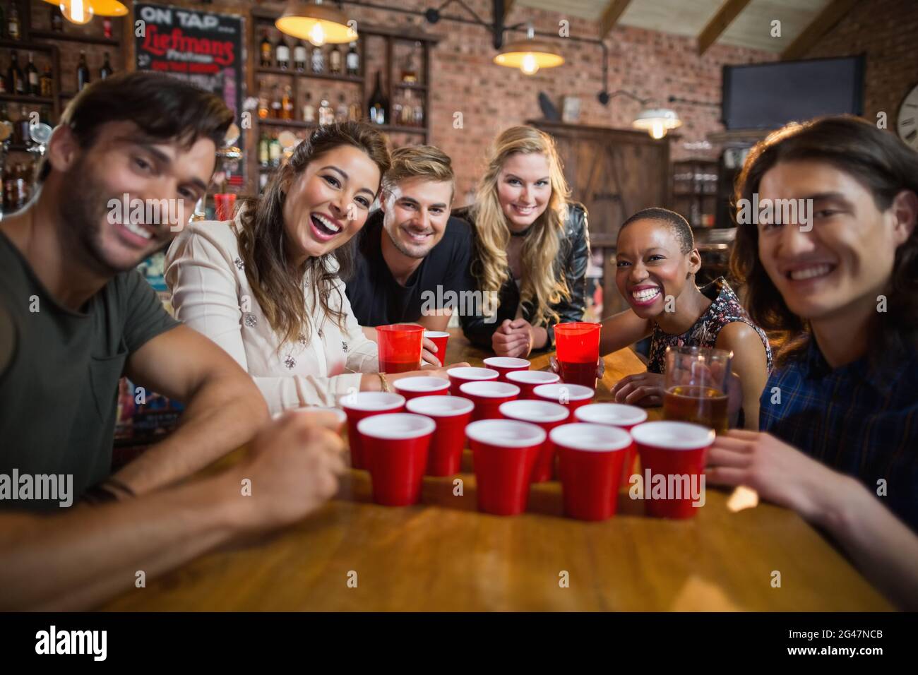 Portrait of smiling friends around disposable cups on table Stock Photo ...