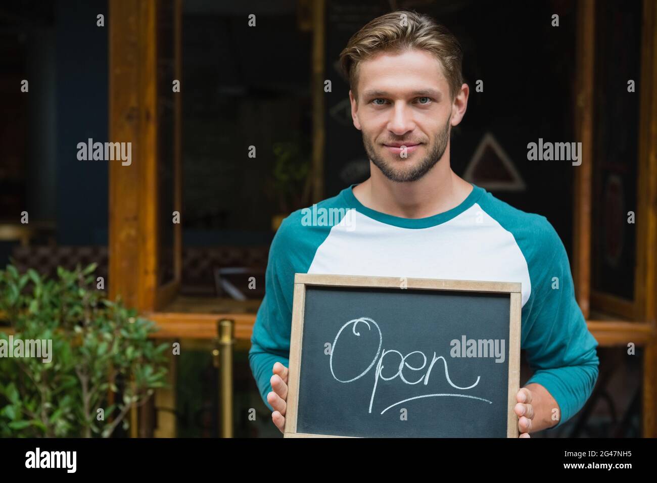 Male waiter standing open sign hi-res stock photography and images - Alamy