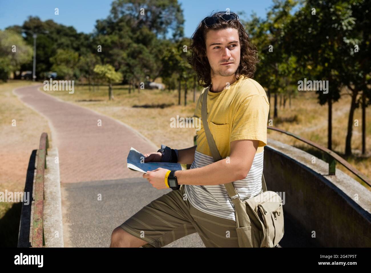 Tourist man holding a map in the park Stock Photo - Alamy