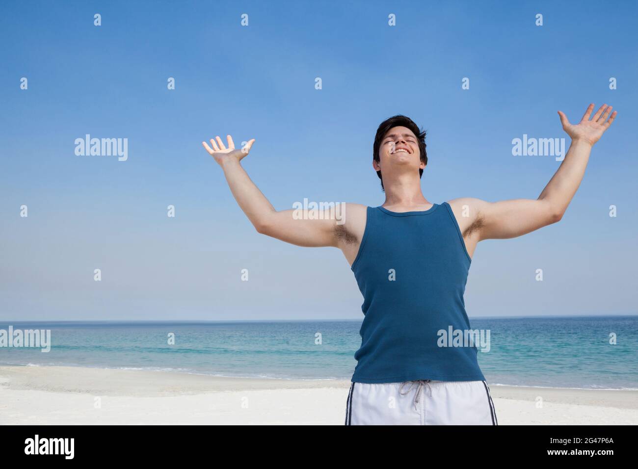 Man standing at beach with arms outstretched Stock Photo - Alamy