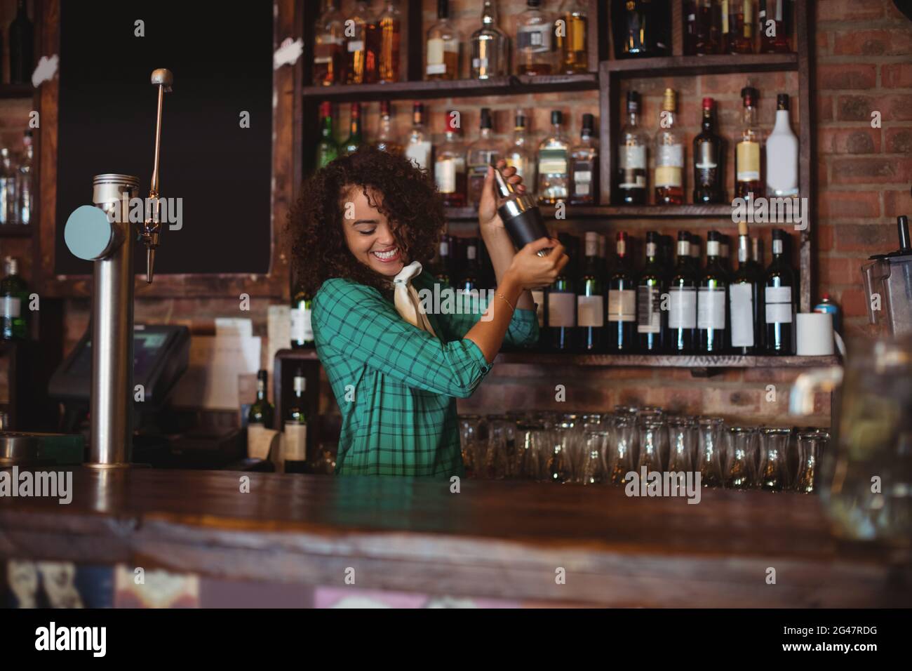 Female bartender mixing a cocktail drink in cocktail shaker Stock Photo ...