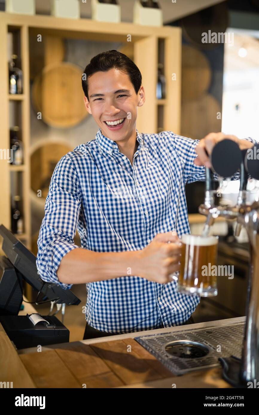 Bar tender filling beer from beer pump Stock Photo - Alamy